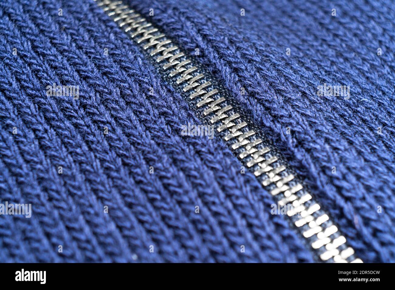 Macro shot of zipper on blue wool texture background with stitching ...