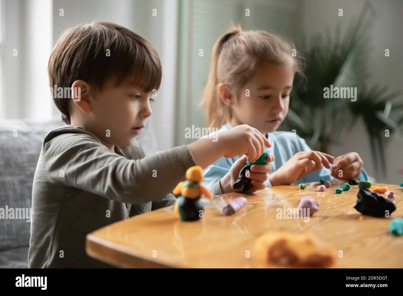 Close up little siblings playing with colorful play dough Stock Photo ...