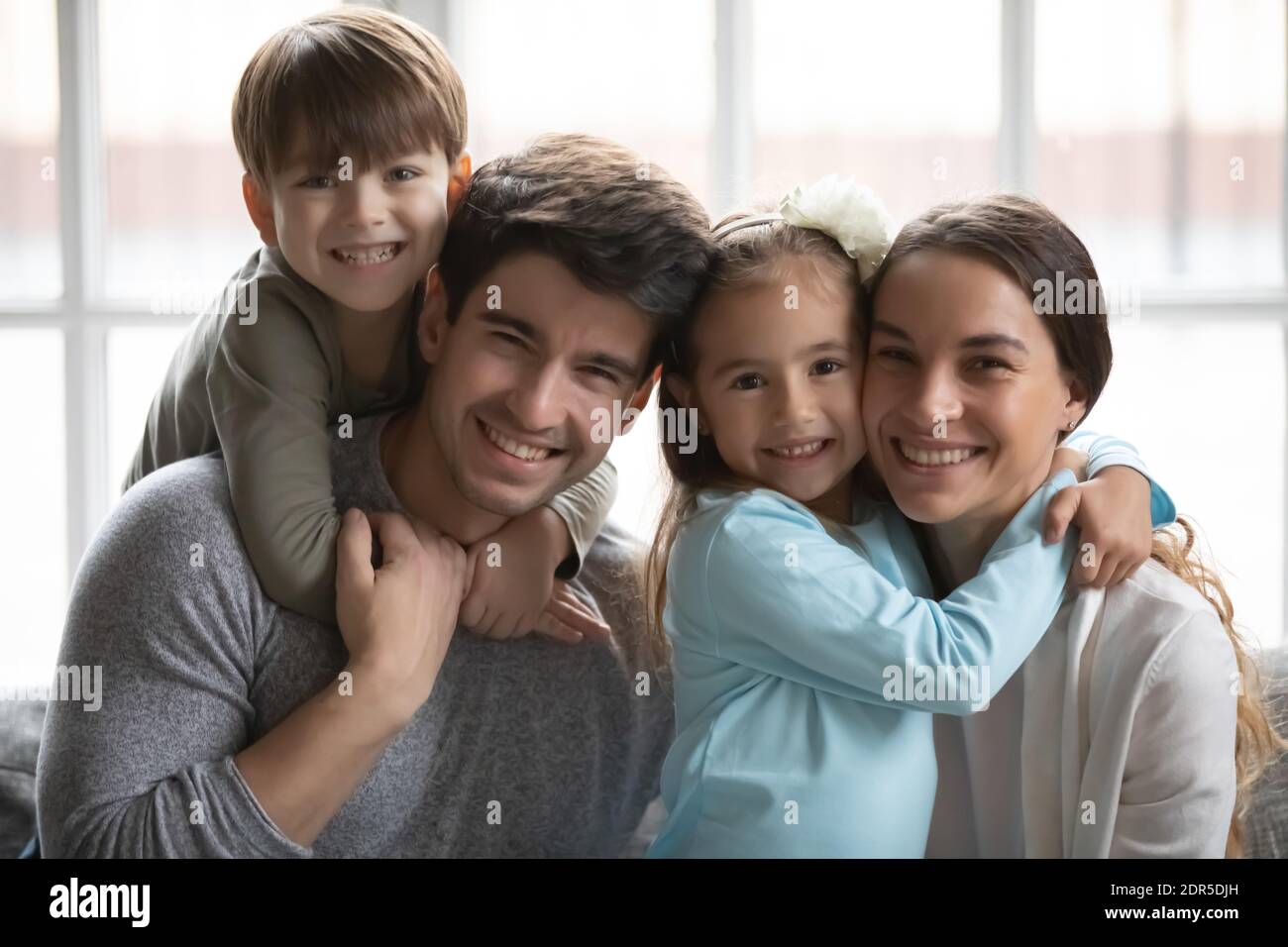 Head shot portrait smiling parents with two adorable little kids Stock ...