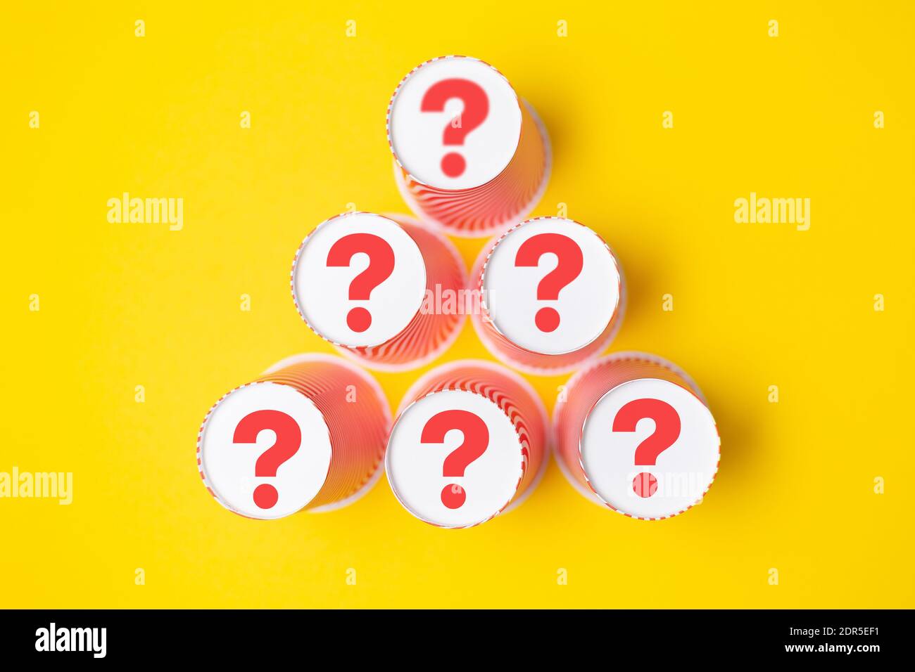 Paper cups arranged in a pyramid with a question mark on the bottom ...