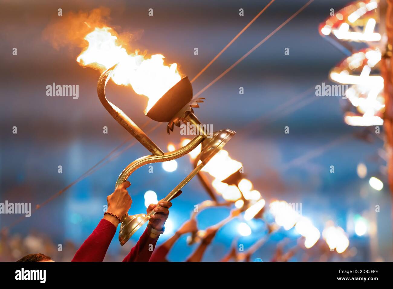 Sacred religious ceremony Arati. Male hands holding a fire lamps at row ...