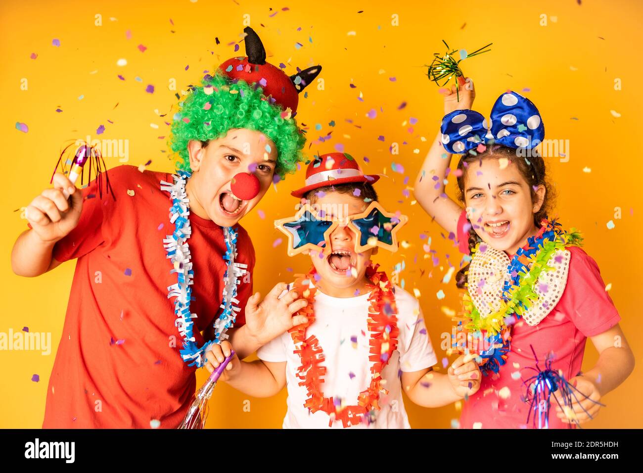 Three kids celebrating Carnival or New Years Eve at home Stock Photo ...