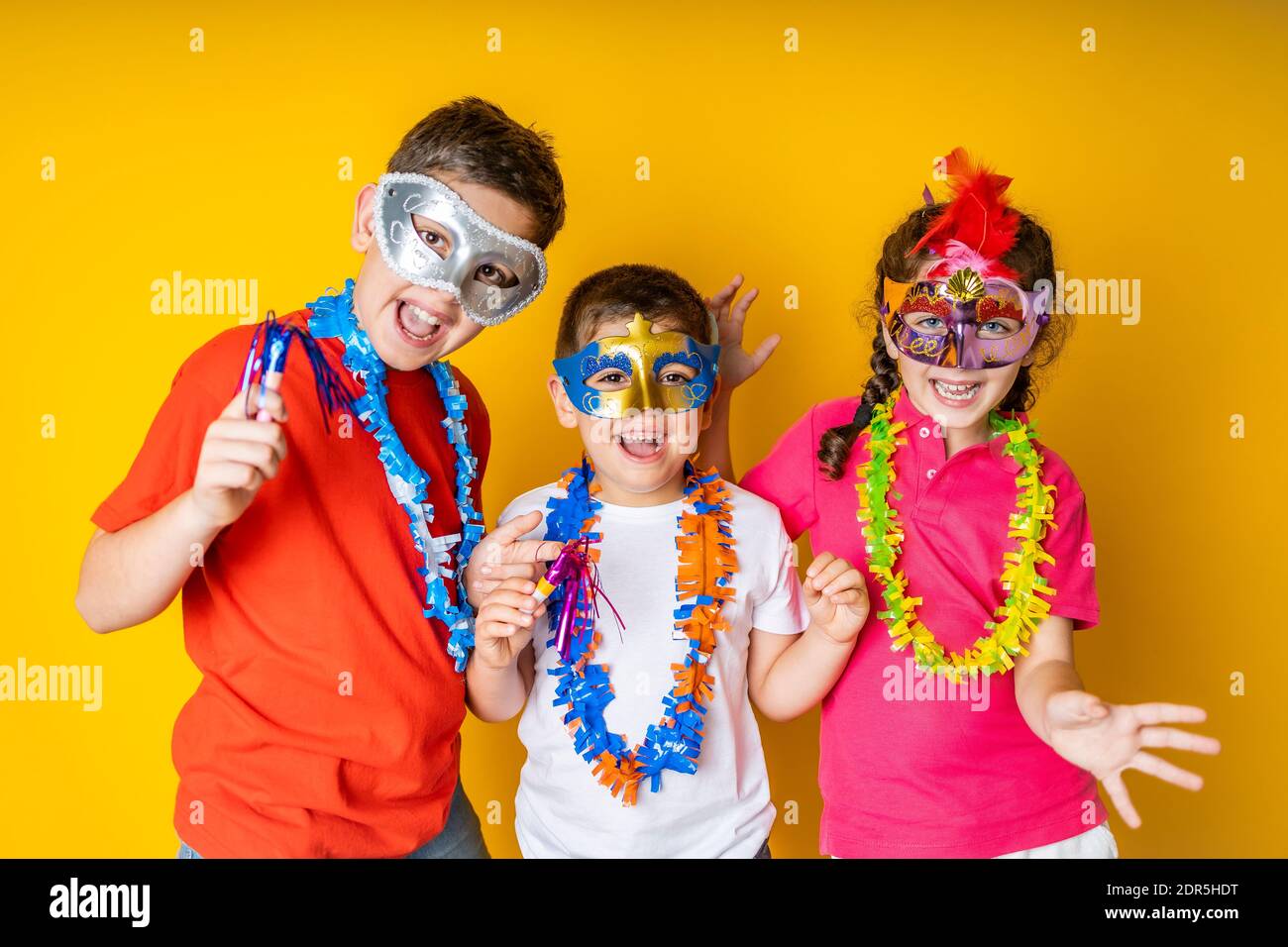 Three kids celebrating Carnival or New Years Eve at home Stock Photo ...
