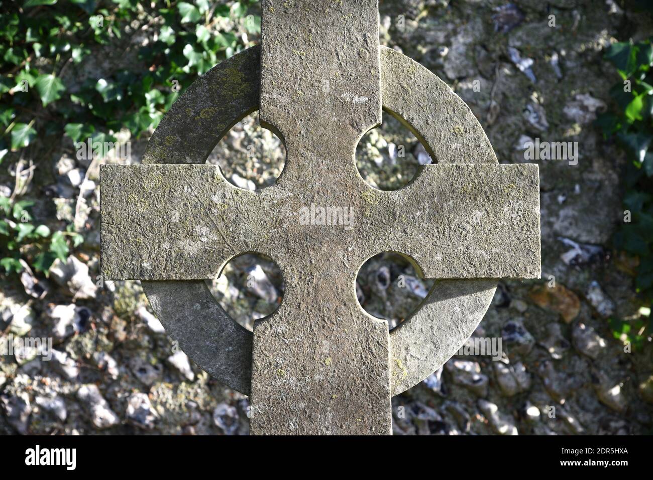 Stone cross against old stone wall in St Margaret's churchyard ...