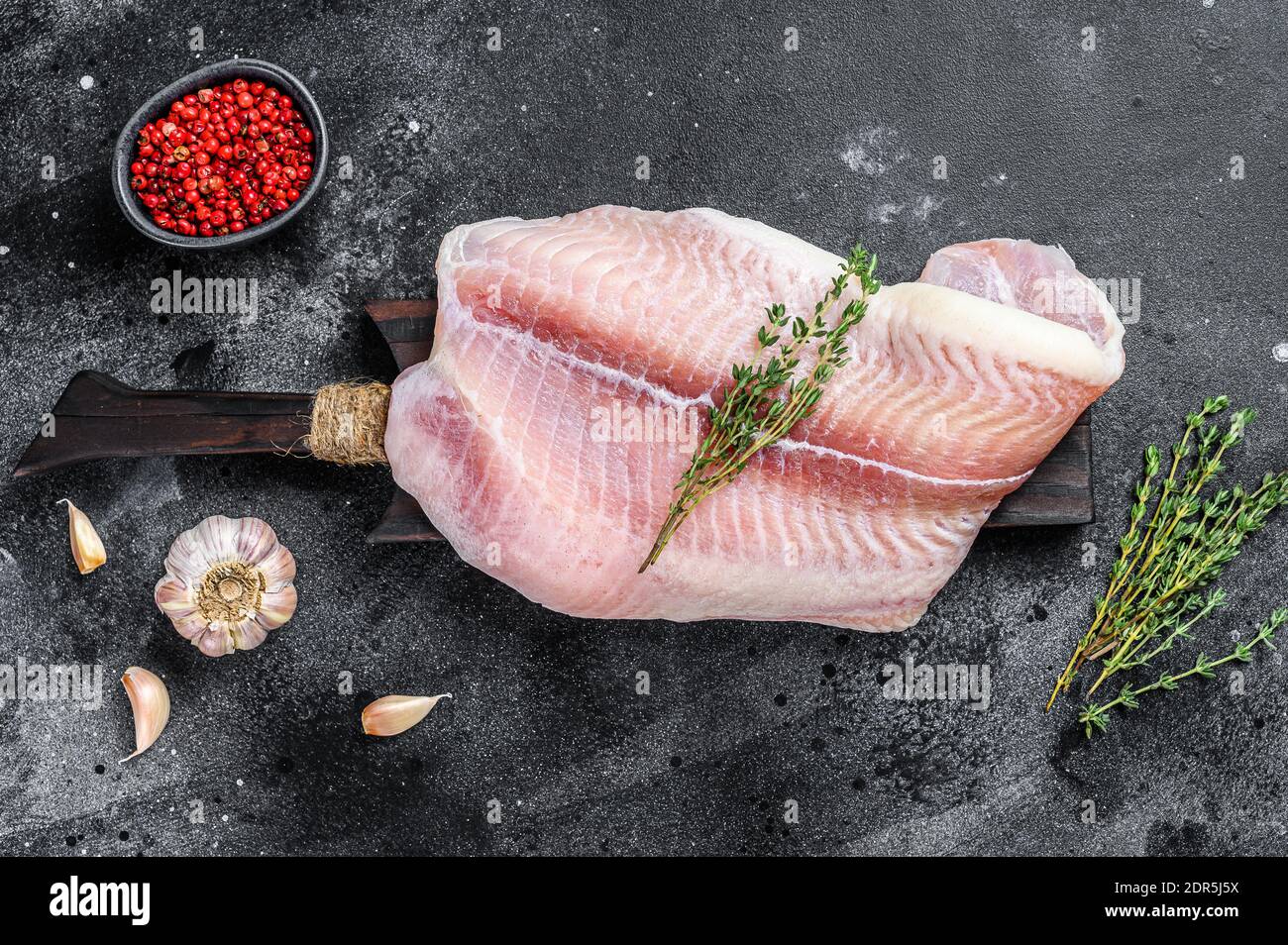 Fresh raw white fish fillet Pangasius with spices. Black background ...