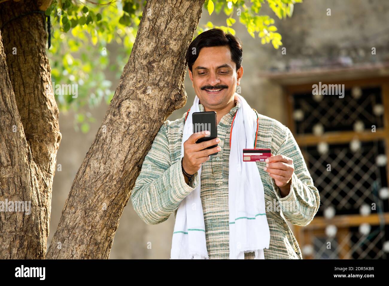 Famer using mobile phone and credit card for payment Stock Photo - Alamy