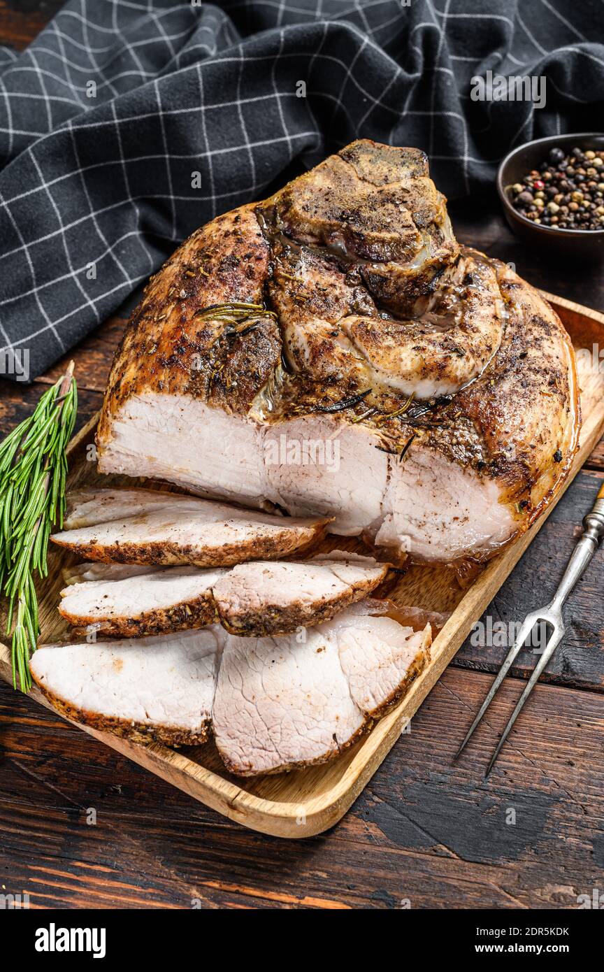 Baked sliced pork leg knuckle. Dark wooden background. Top view Stock ...