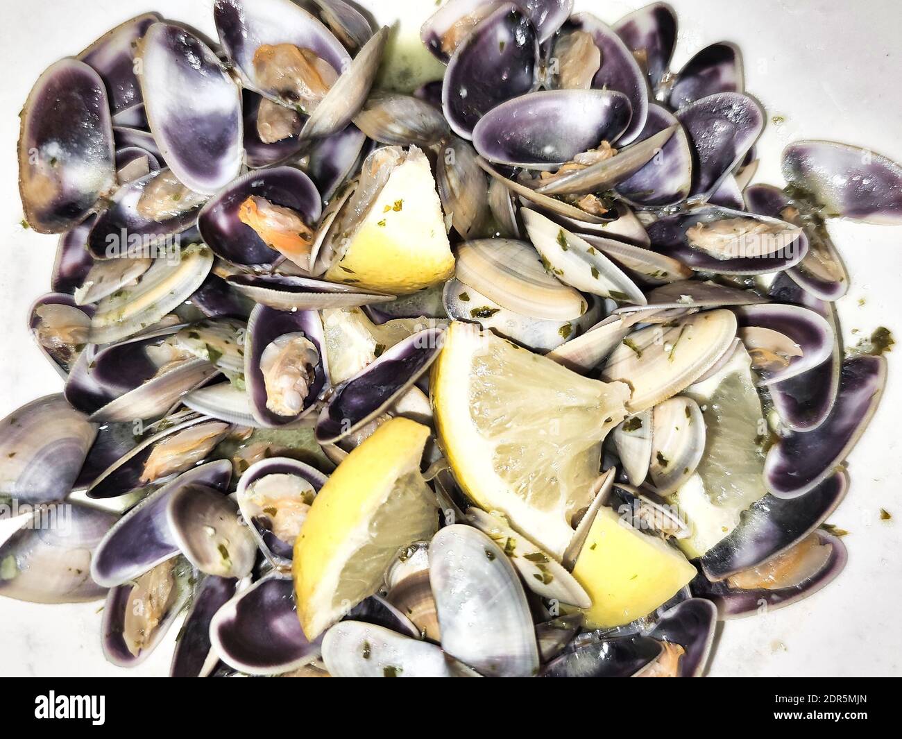 A top view of a traditional clam meal with lemon in Valencia, Spain ...