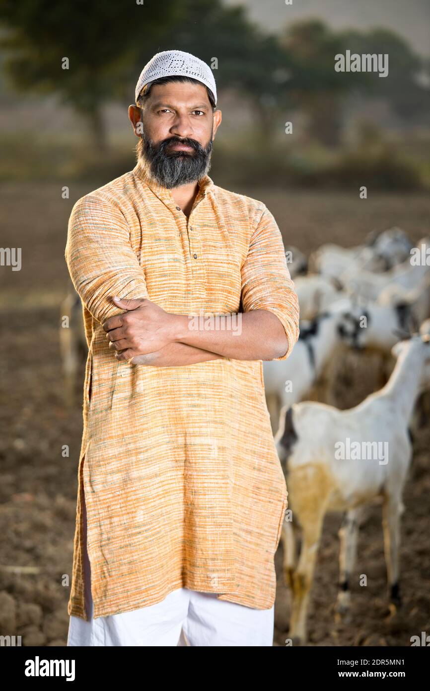 Muslim shepherd man with herd of goat on field Stock Photo - Alamy