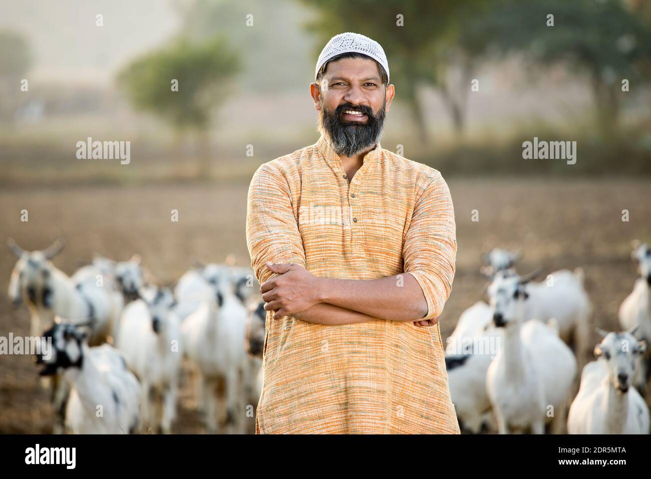 Muslim shepherd man with herd of goat on field Stock Photo - Alamy
