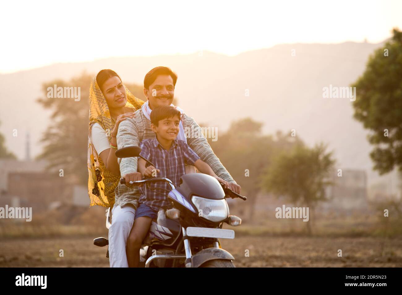 Happy rural Indian family riding on motorcycle Stock Photo - Alamy