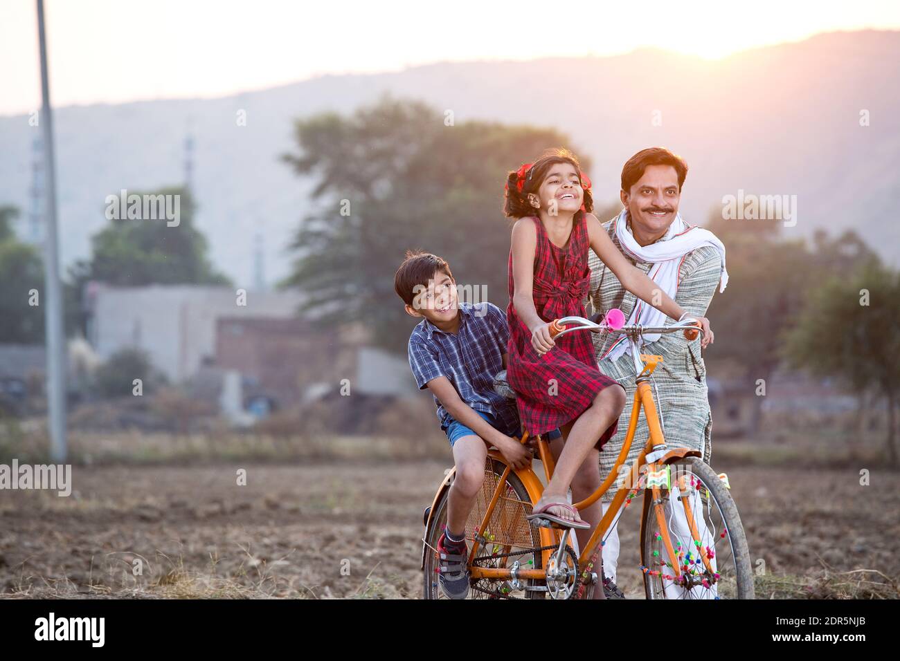 Happy rural Indian farmer with children riding on bicycle Stock Photo ...