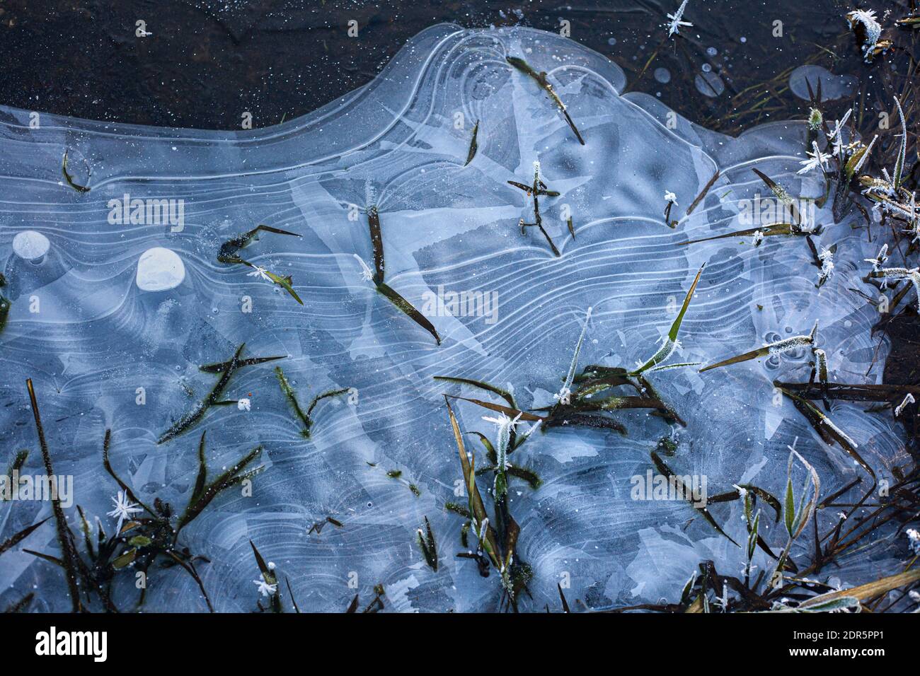 The texture of the ice on the river. The bank of the stream is frozen ...