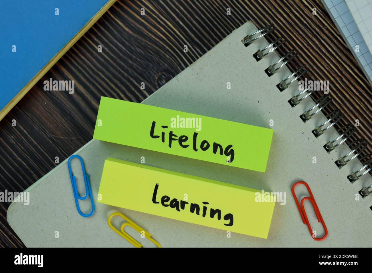 Lifelong learning write on sticky notes isolated on Wooden Table ...