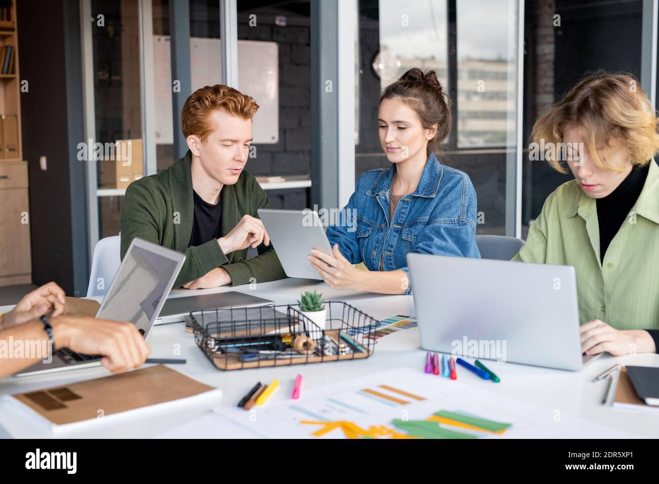 Confident young male mobile app developer presenting his female ...