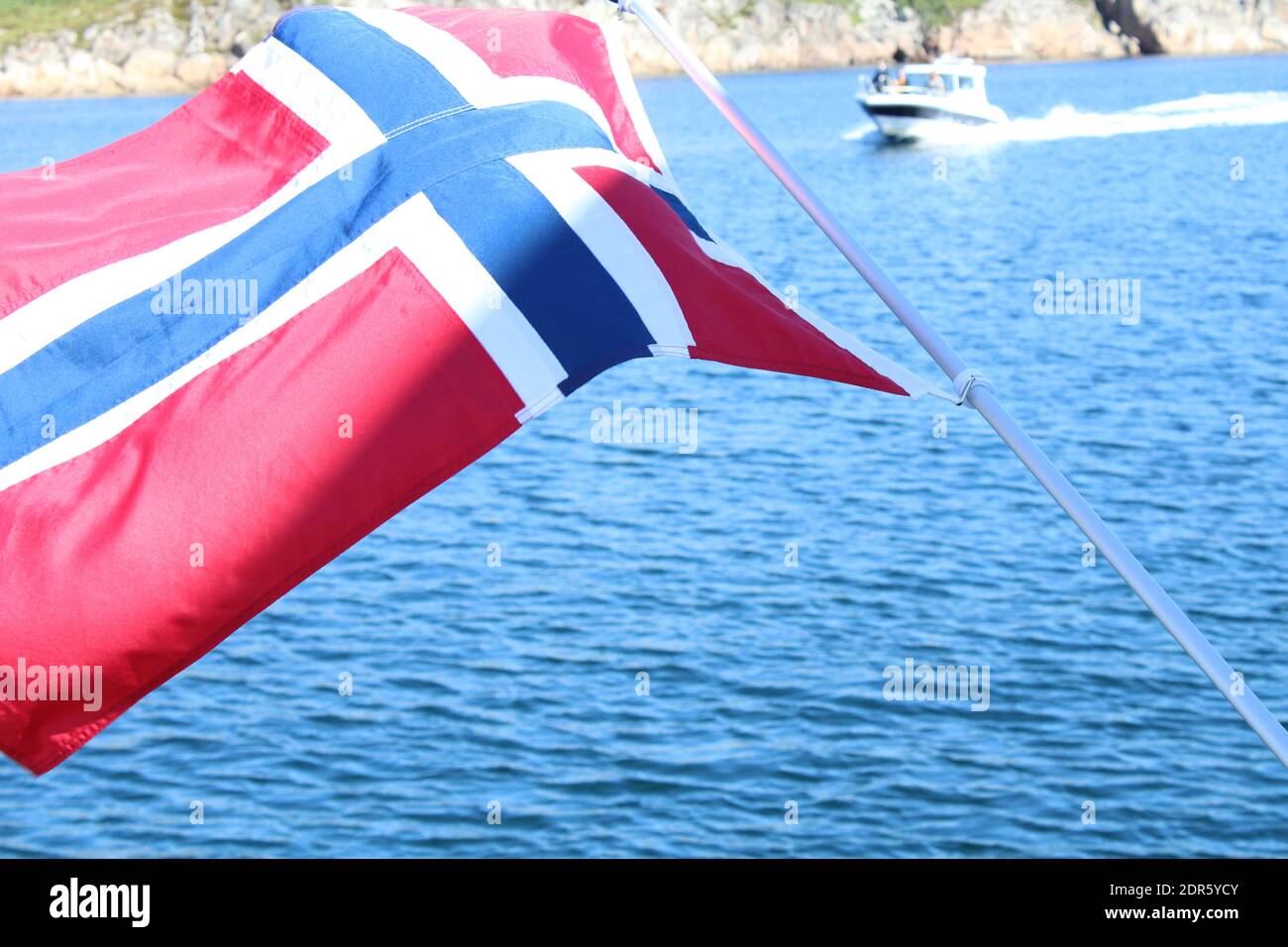 Wedding arch with flowers, red rose and a norwegian flag waiving in the ...