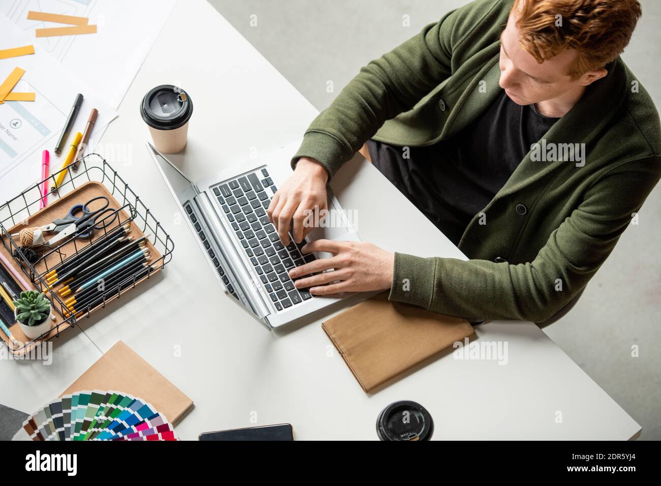 Young contemporary software developer pressing buttons of laptop keypad ...