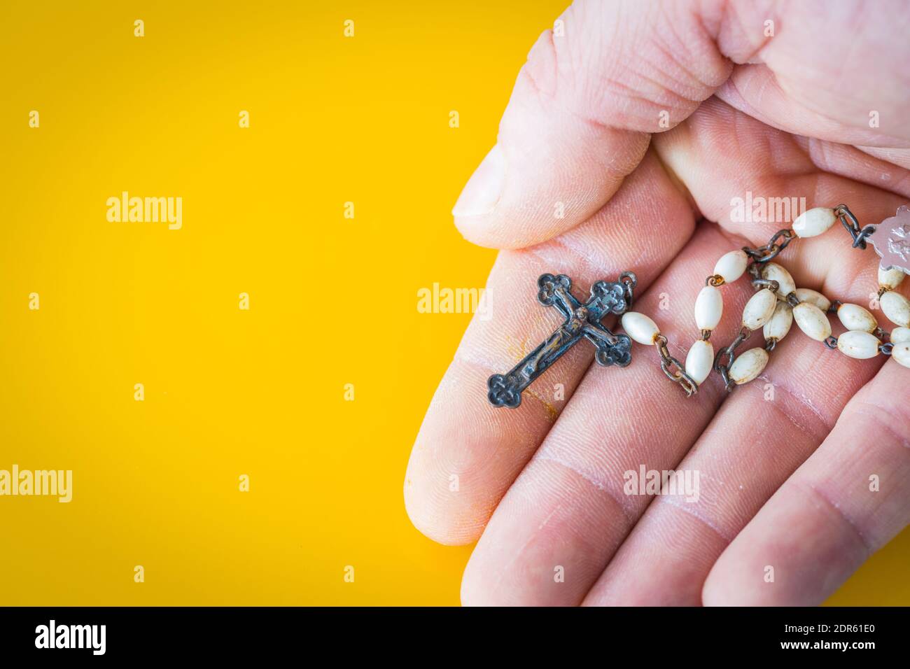 Hand-held Christian rosary. Yellow background. Place for text Stock ...