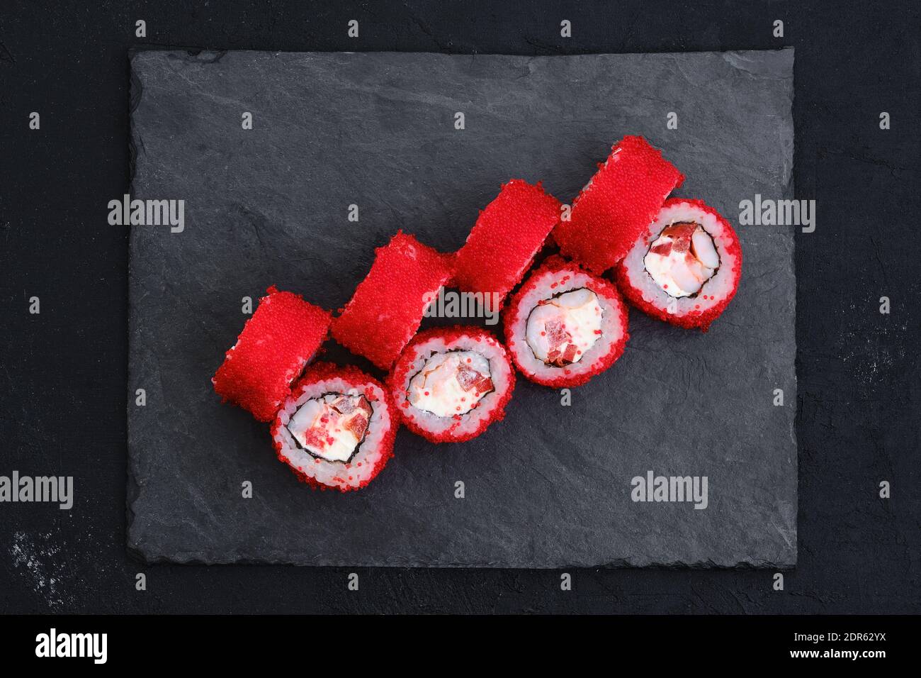 Rolls with shrimp and flying fish roe on slate plate Stock Photo - Alamy