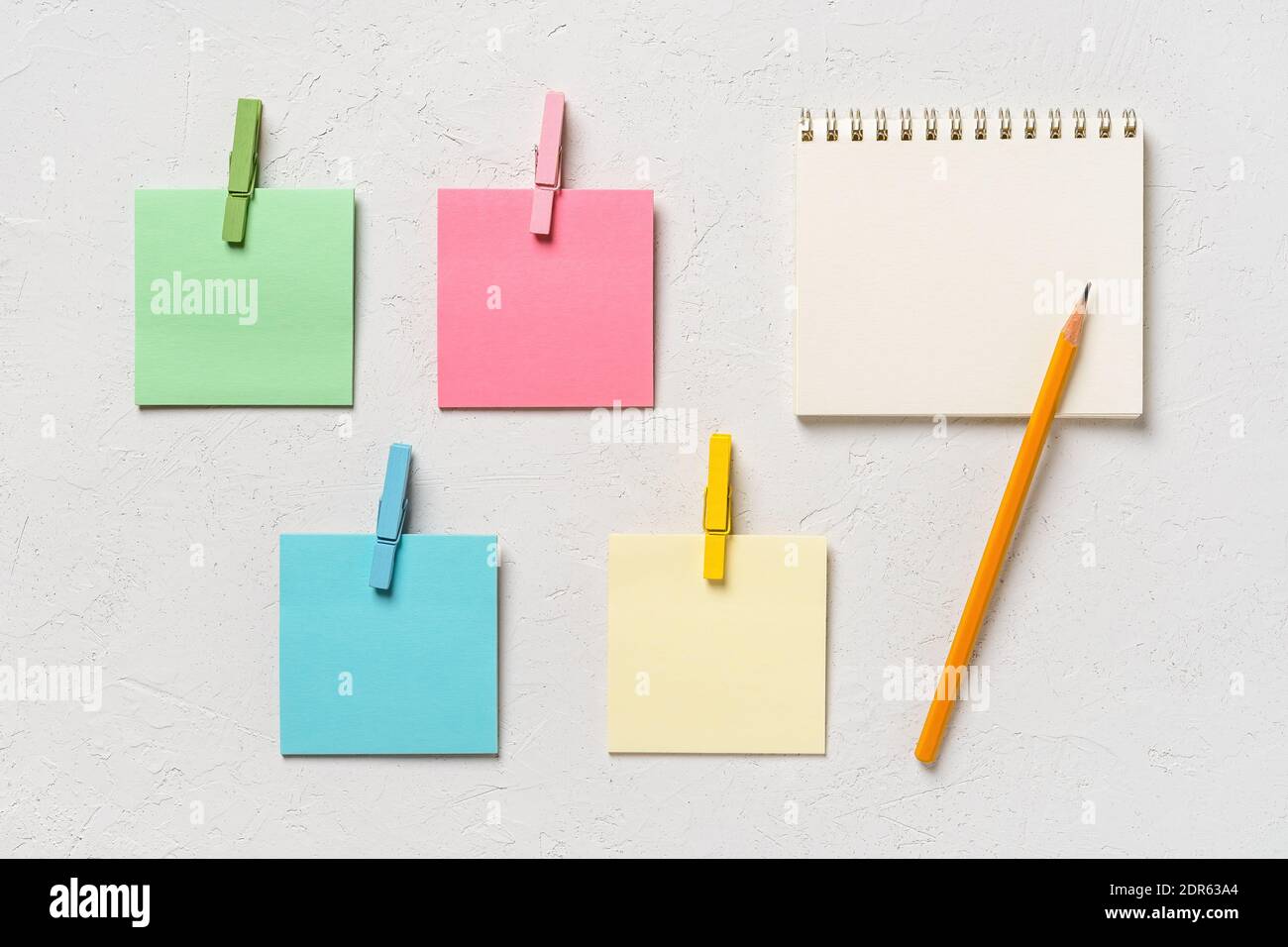 Four colorful blank post-it notes every with wooden clothespin and ...