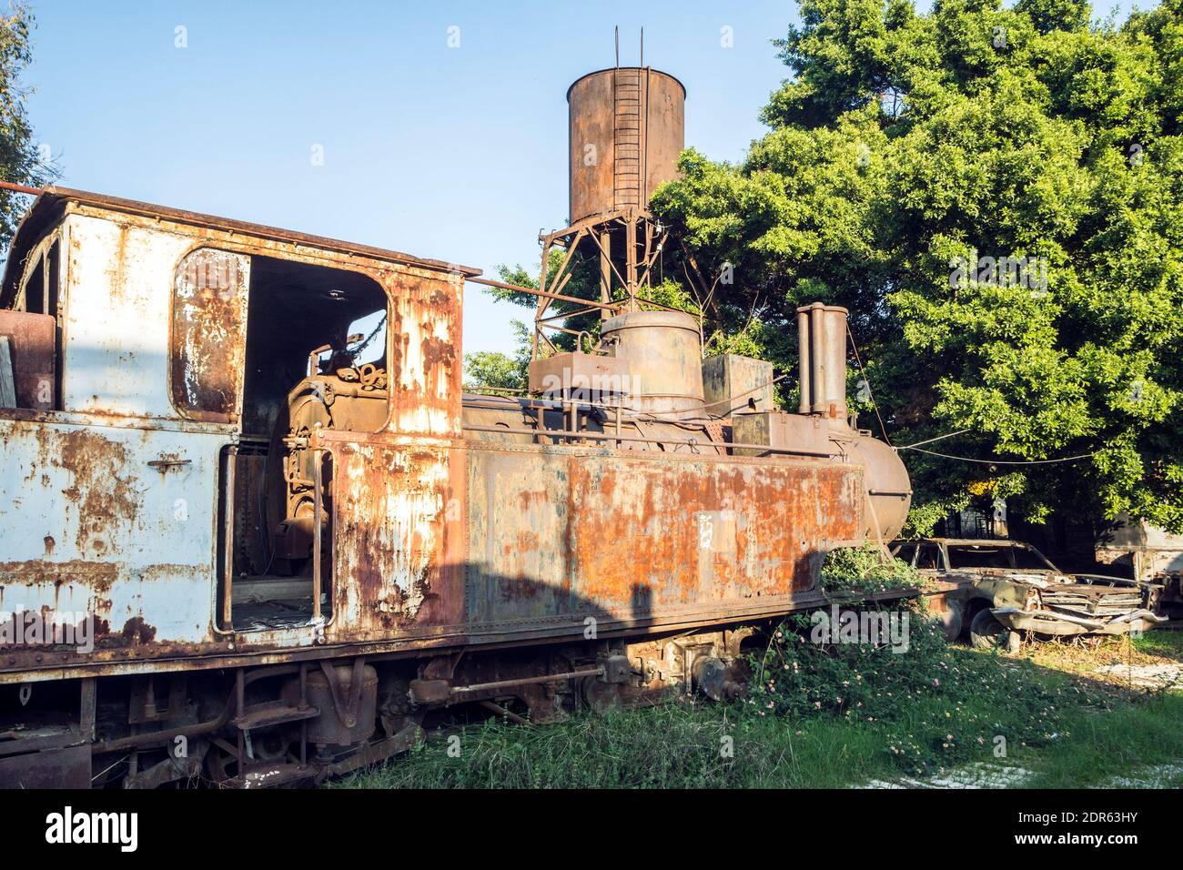 Old rusty abandoned train with a broken car and rusty elevated water ...