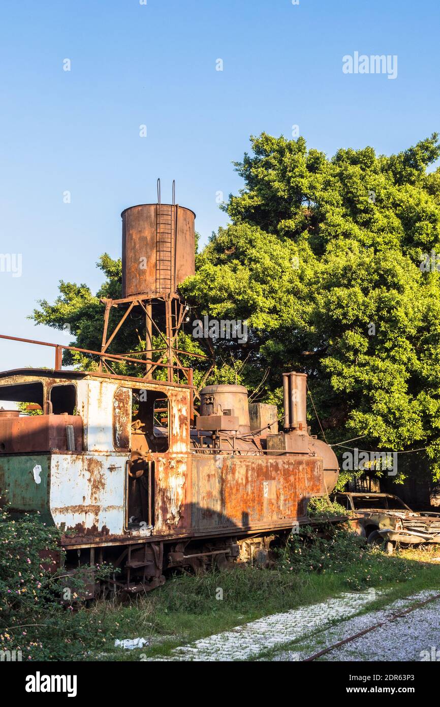 Old rusty abandoned train with a broken car and rusty elevated water ...