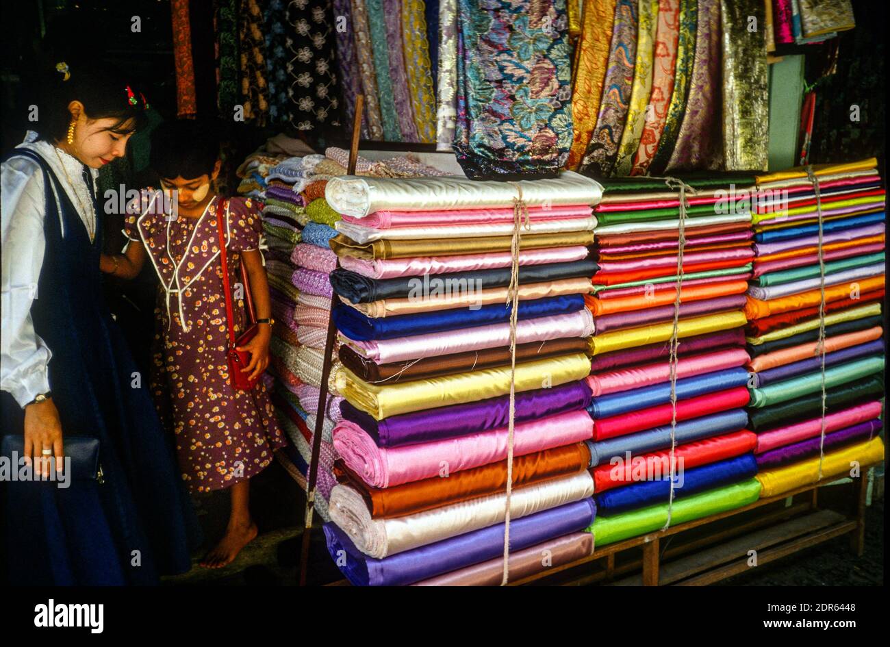 Large stacks of colourful textiles at the Bogyoke Aung San market ...