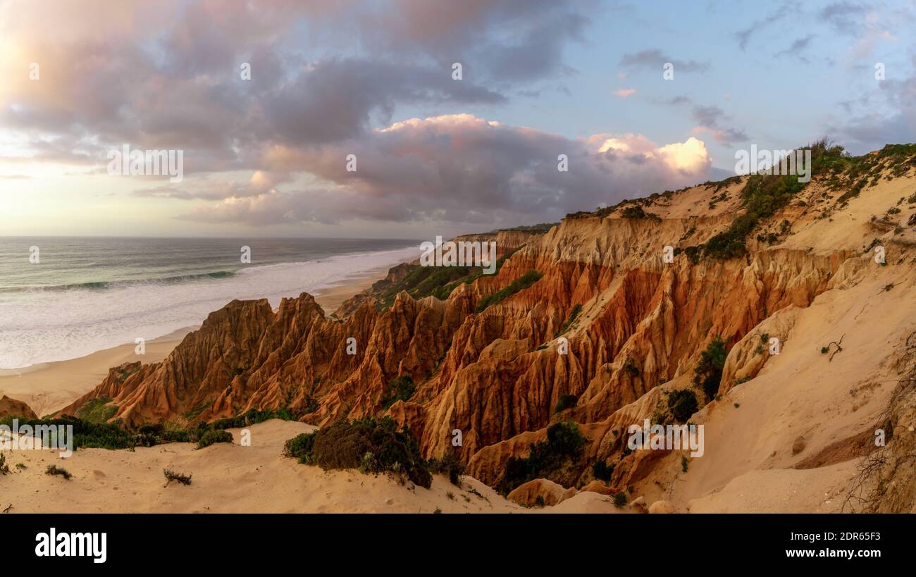 Many bizarre eroded sand dunes on the Atlantic Ocean with waves rolling ...