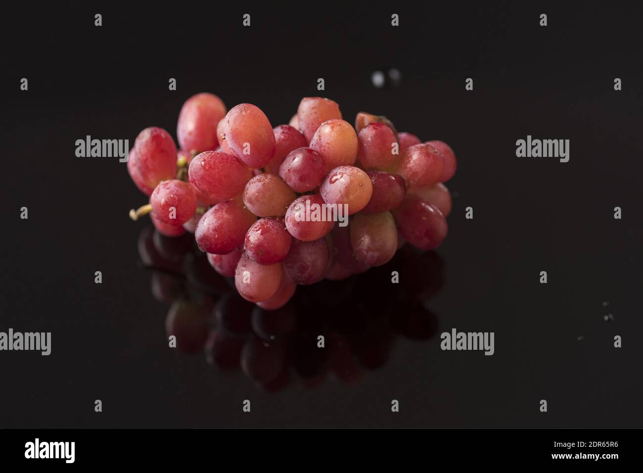 Top view closeup of red grapes isolated on a black background with ...