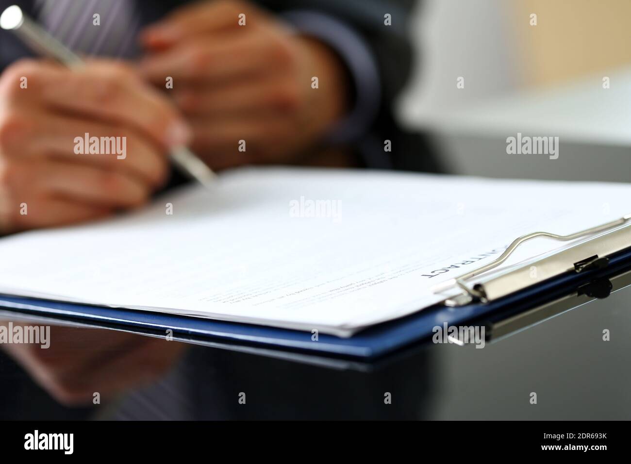 Male arm in suit and tie fill form clipped to pad Stock Photo - Alamy