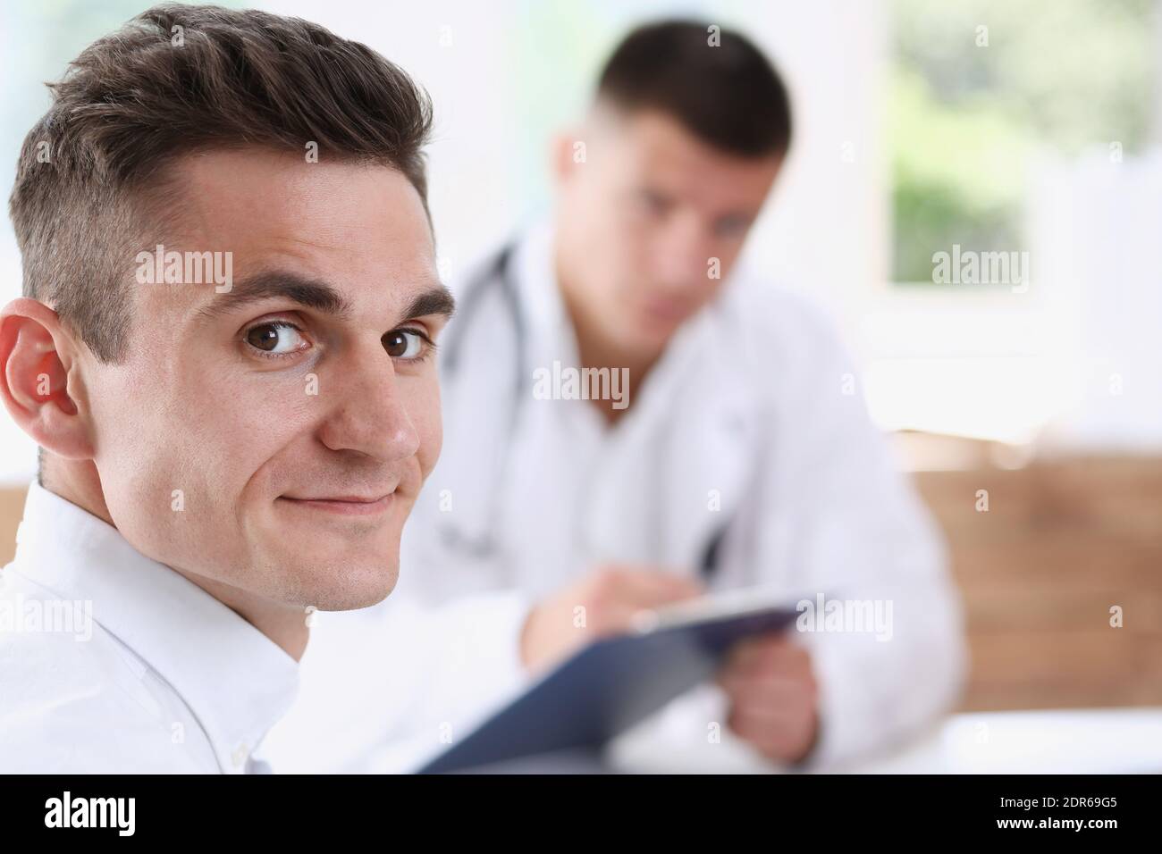 Satisfied happy handsome smiling male patient with doctor Stock Photo ...