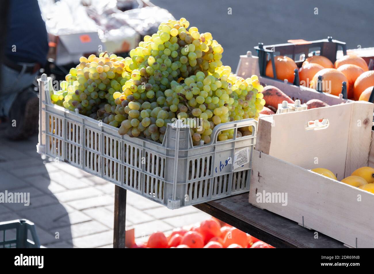 Bunches of grapes in a plastic tray at the market. Selling vegetables ...