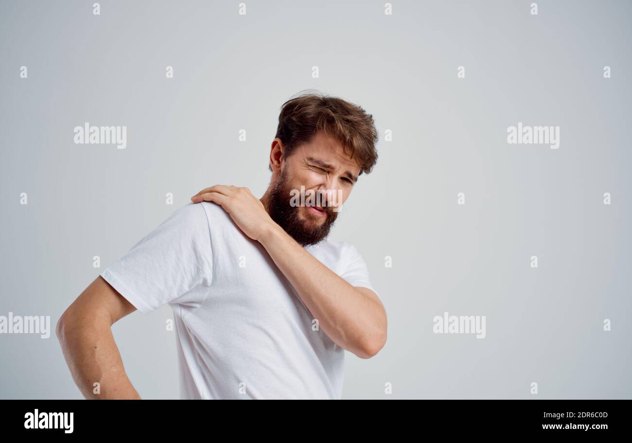 man touching shoulder with hand dislocation discomfort white t-shirt ...
