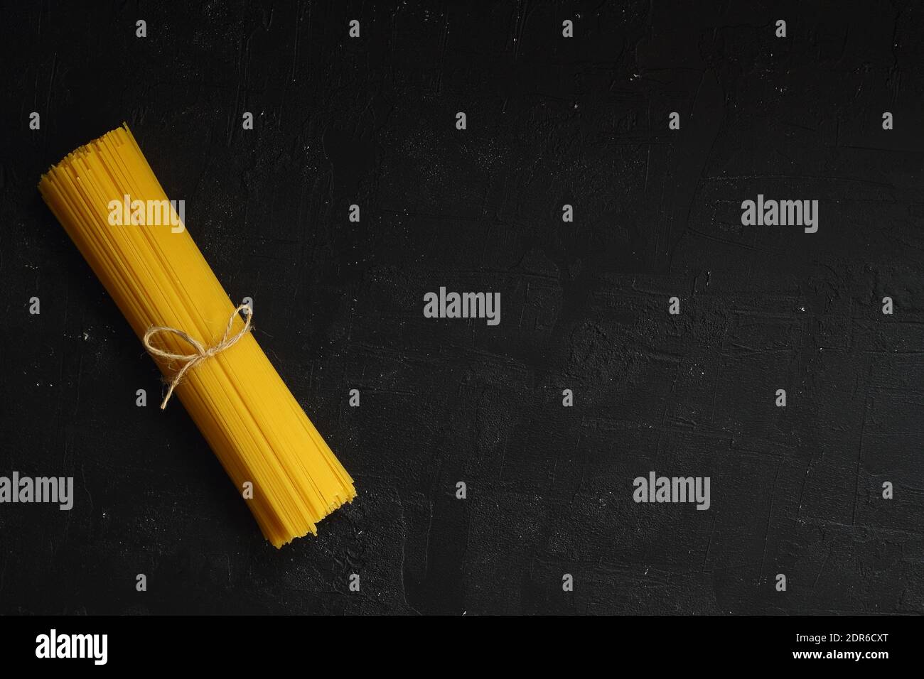 Flat lay of spaghetti for cooking italian pasta over black background ...