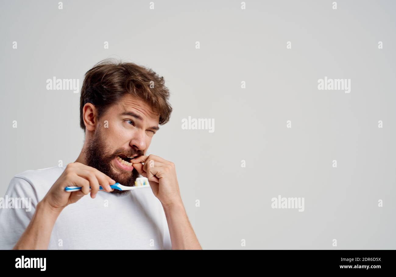 toothache man with beard light background t-shirt model oral cavity ...