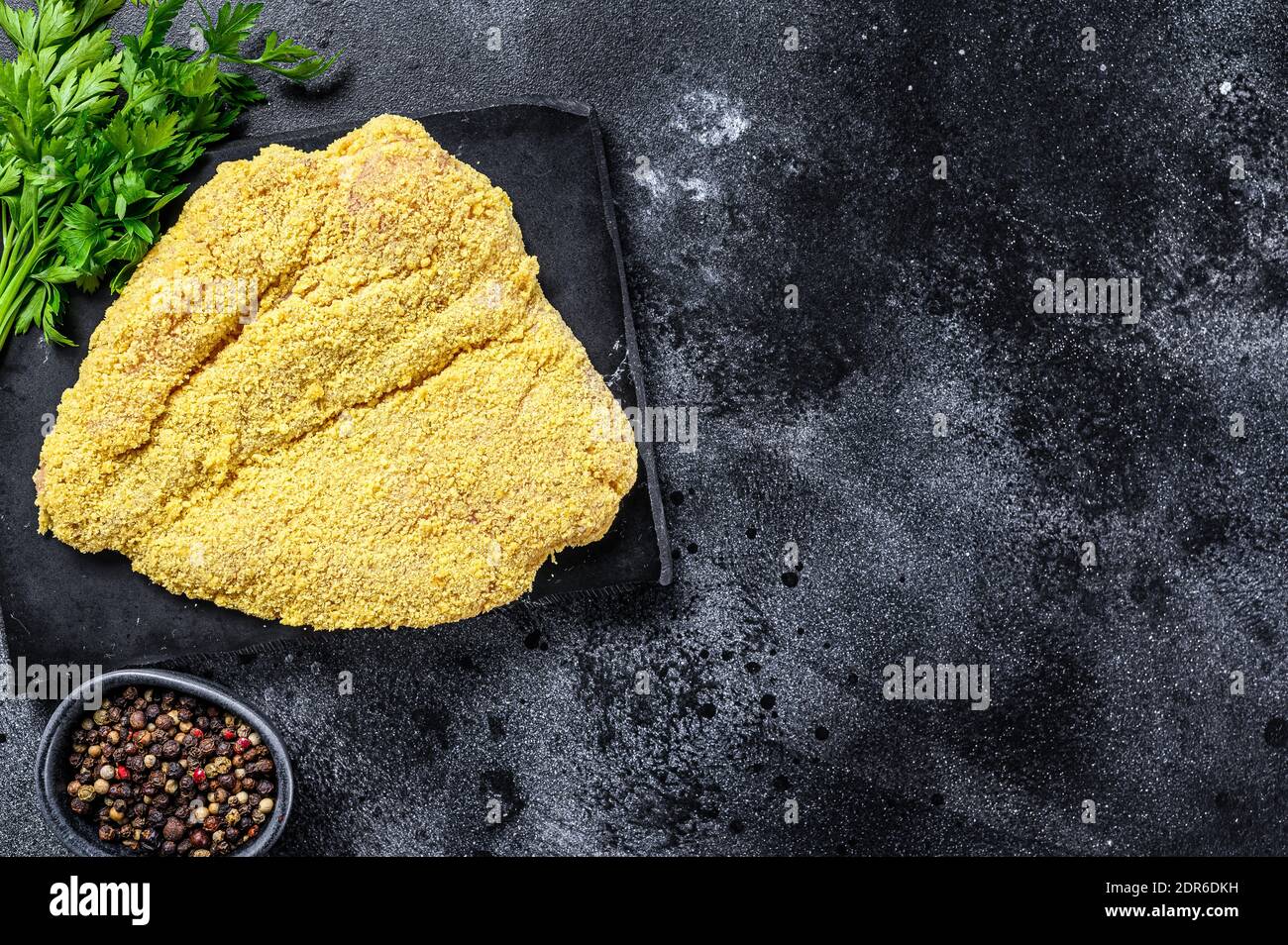 Raw Breaded German Weiner Schnitzel. Black background. Top view. Copy ...