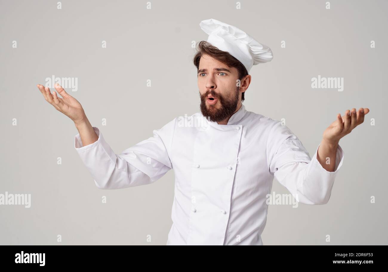 The professional chef gestures with his hands on a light background ...