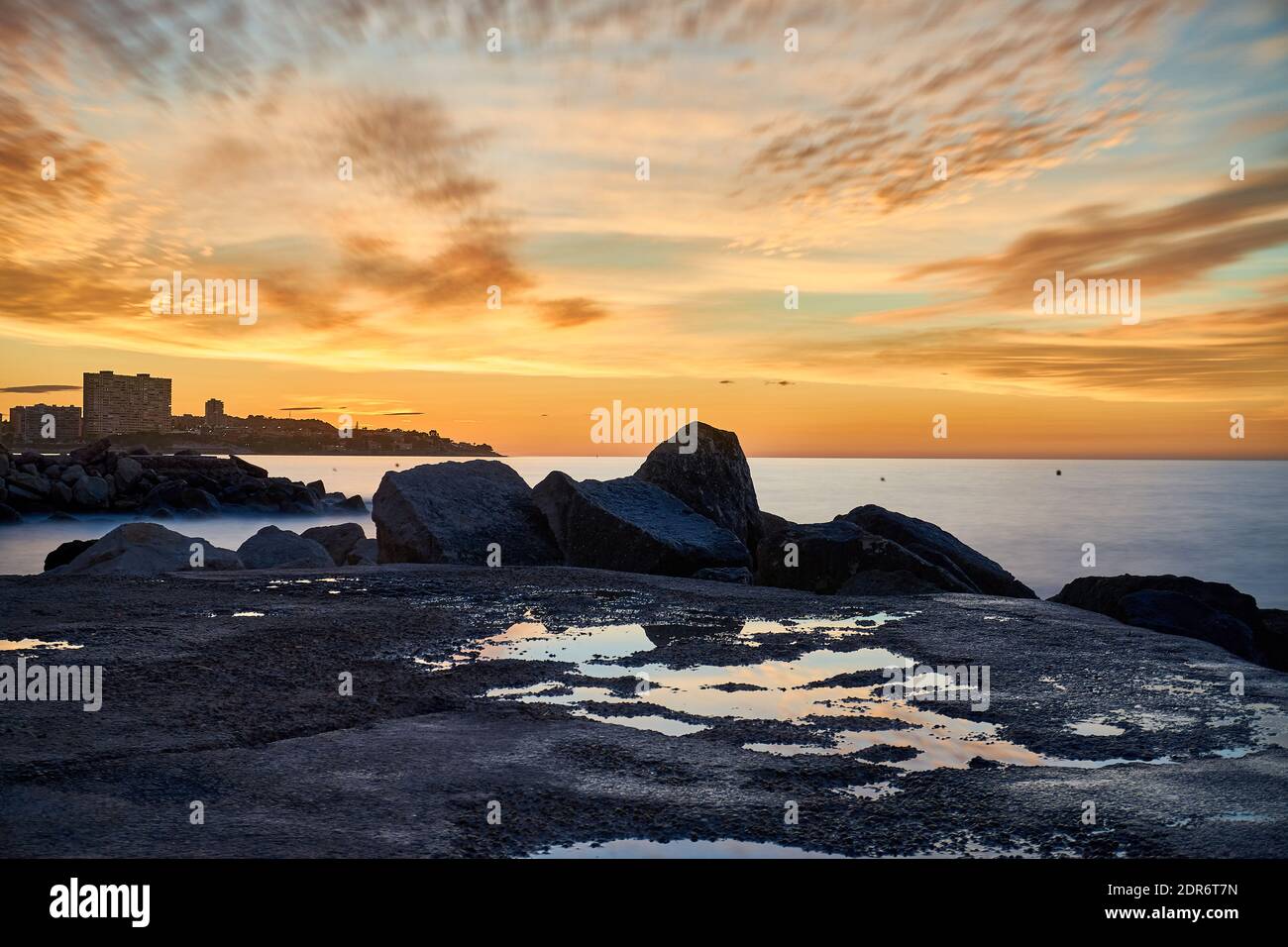 beautiful sunrise on the beach with rocks Stock Photo - Alamy