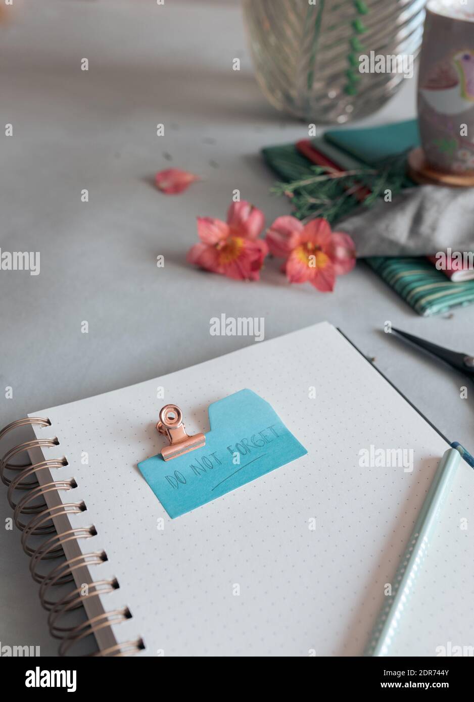 Empty spiral notebook with a dotted pencil and a Do Not Forget note ...