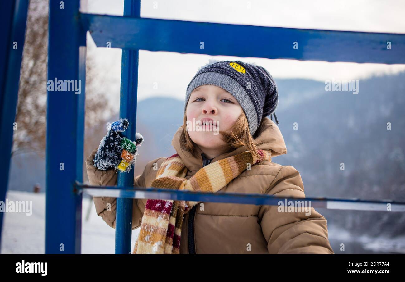 Little boy having fun, playing outside in cold weather. Wintertime ...