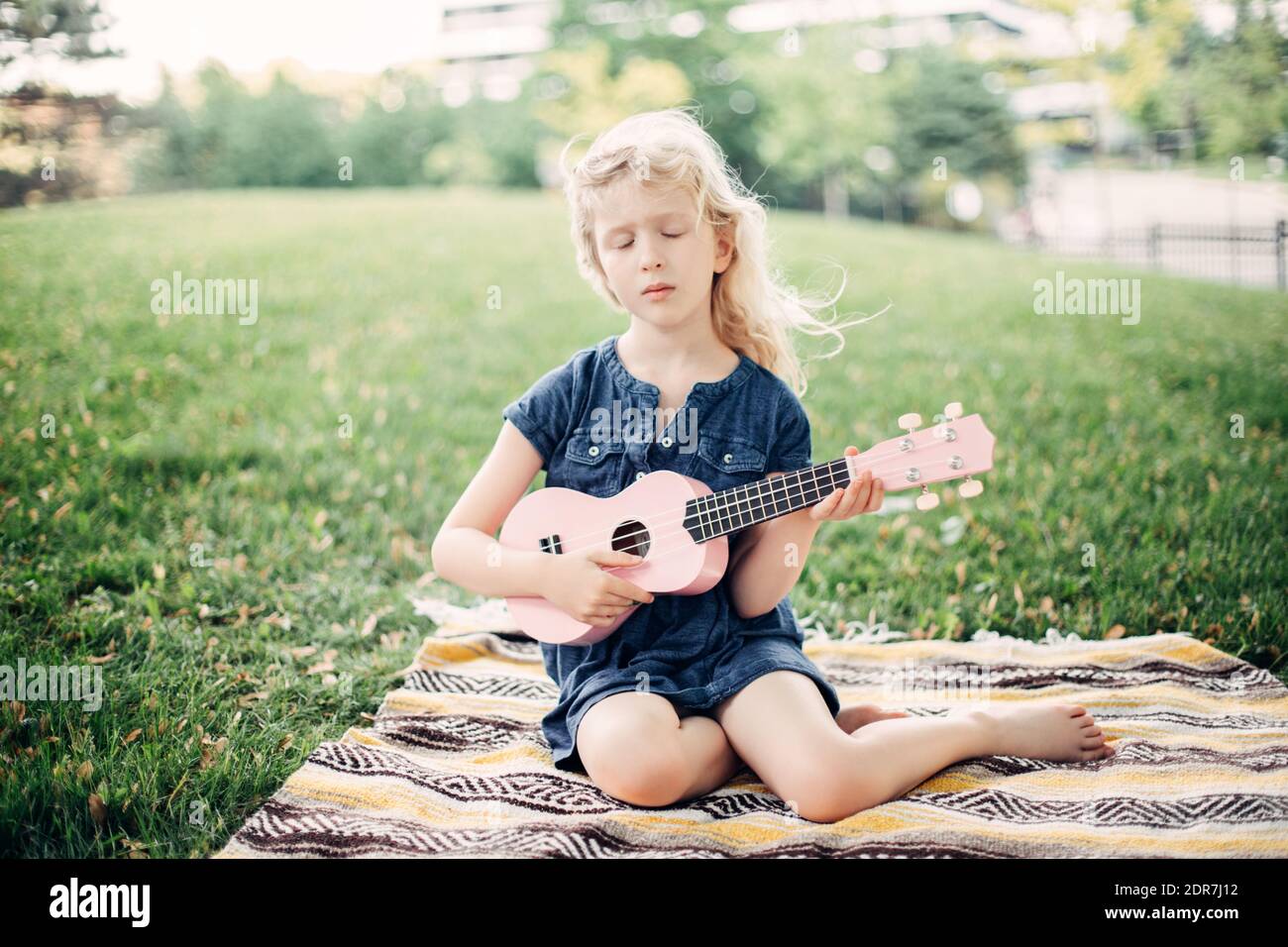Full Length Of Girl Sitting On Grass Stock Photo - Alamy