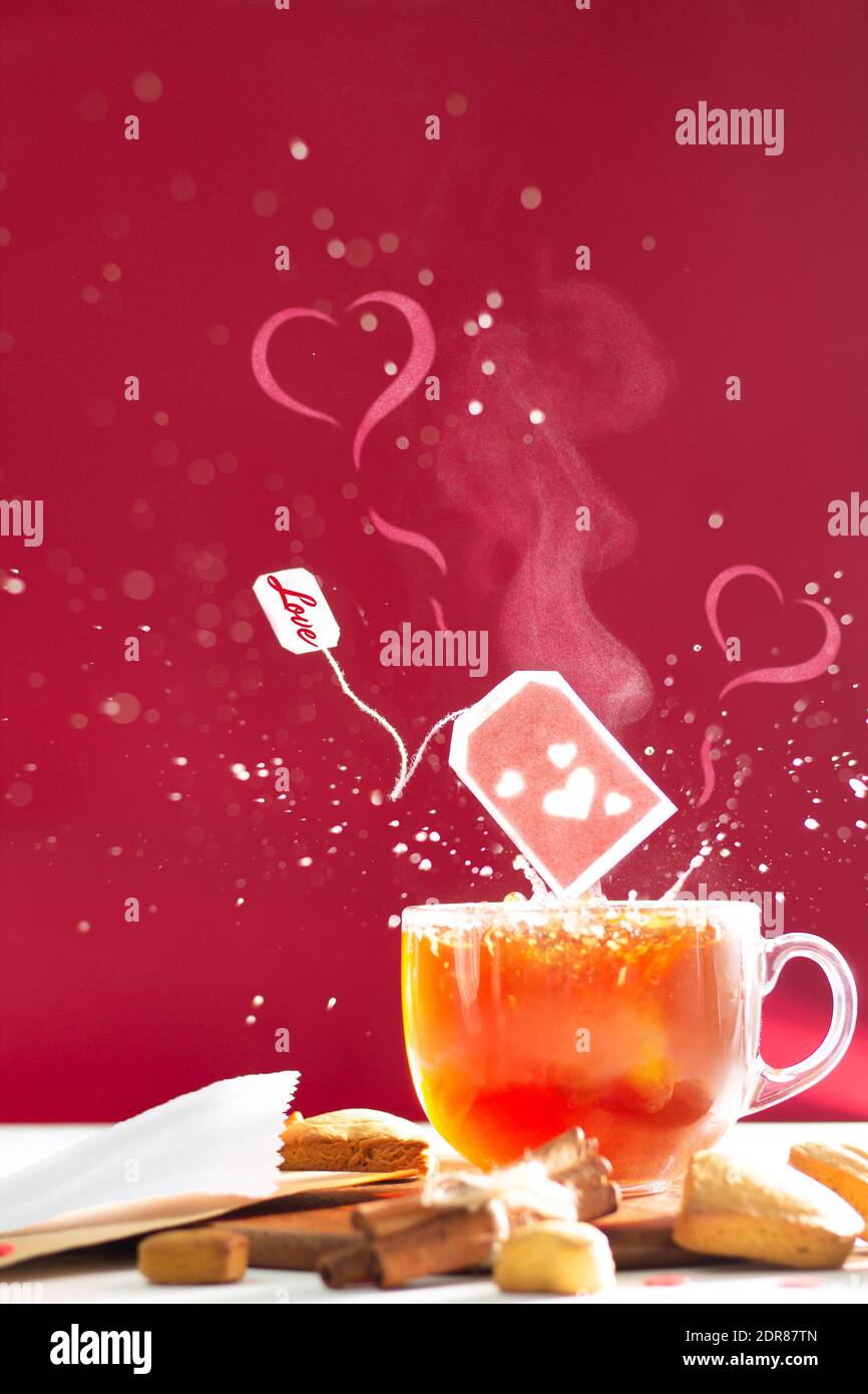Tea bag with hearts and inscription Love on label above tea mug with ...