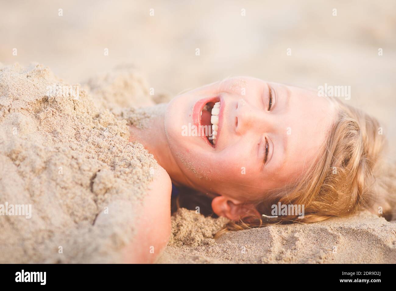 Girl buried in sand hi-res stock photography and images - Alamy