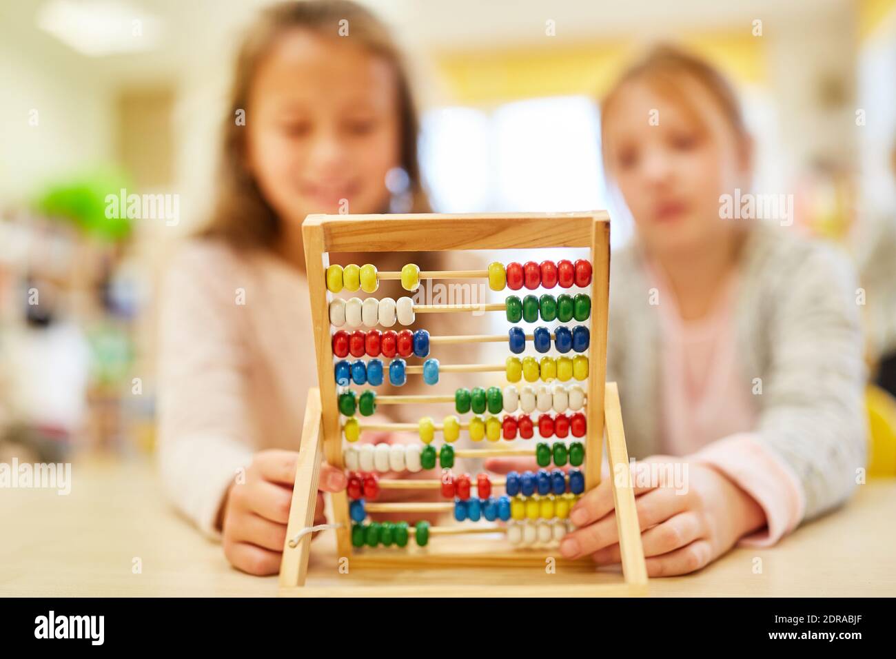 Students Using Abacus While Sitting On Table In Classroom Stock Photo ...
