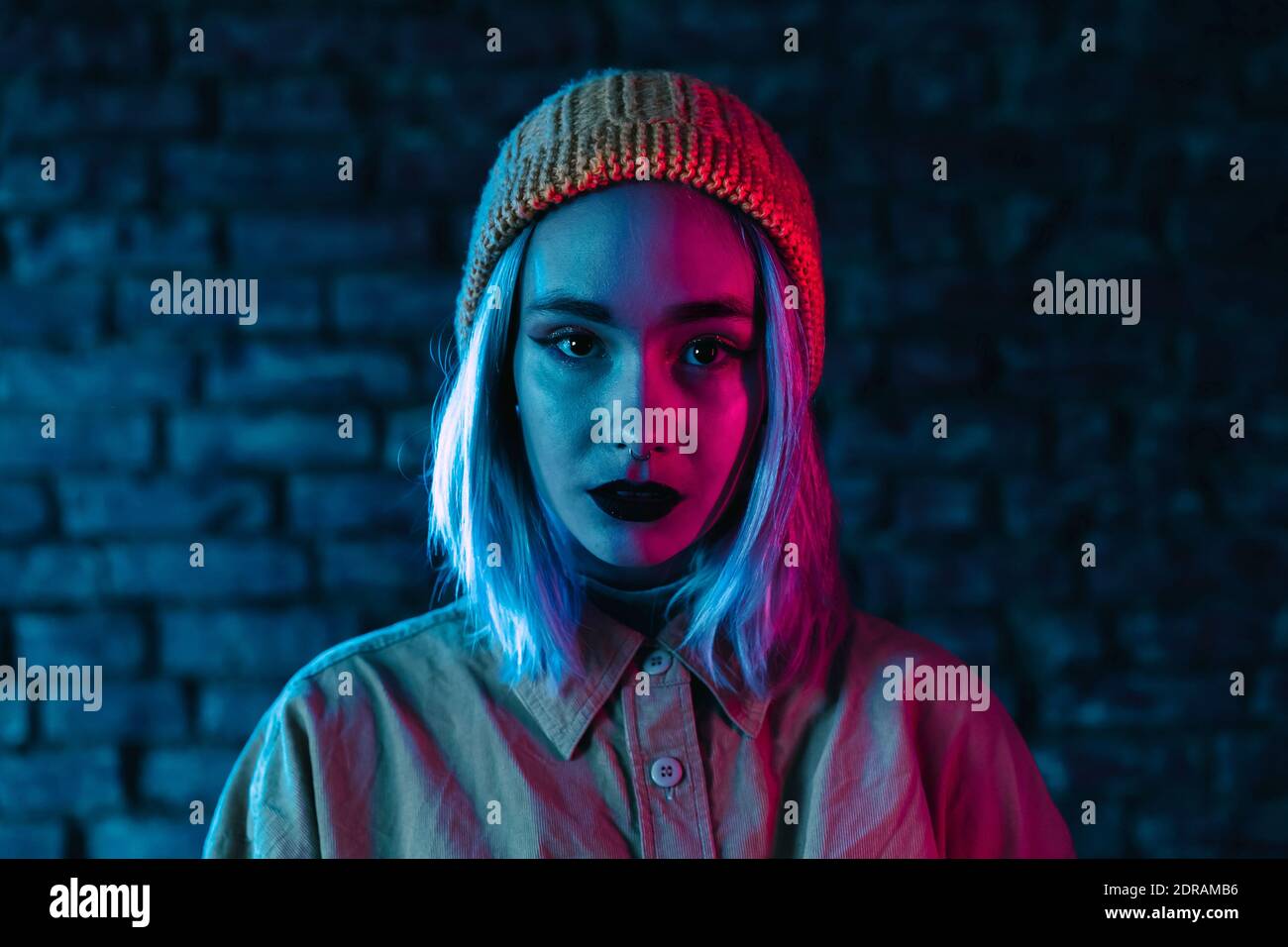 Portrait Of Woman Standing Against Brick Wall Stock Photo - Alamy