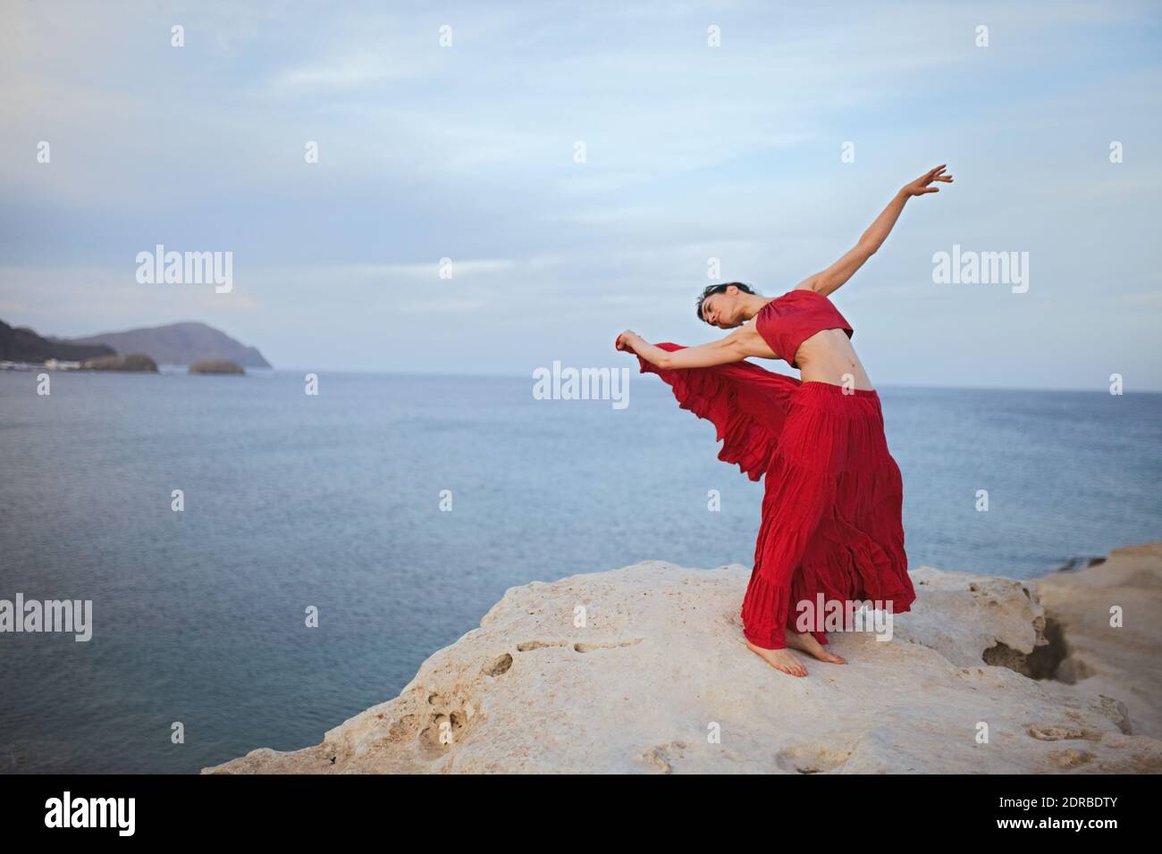 Woman In Red Dress On Rock Formation Stock Photo - Alamy