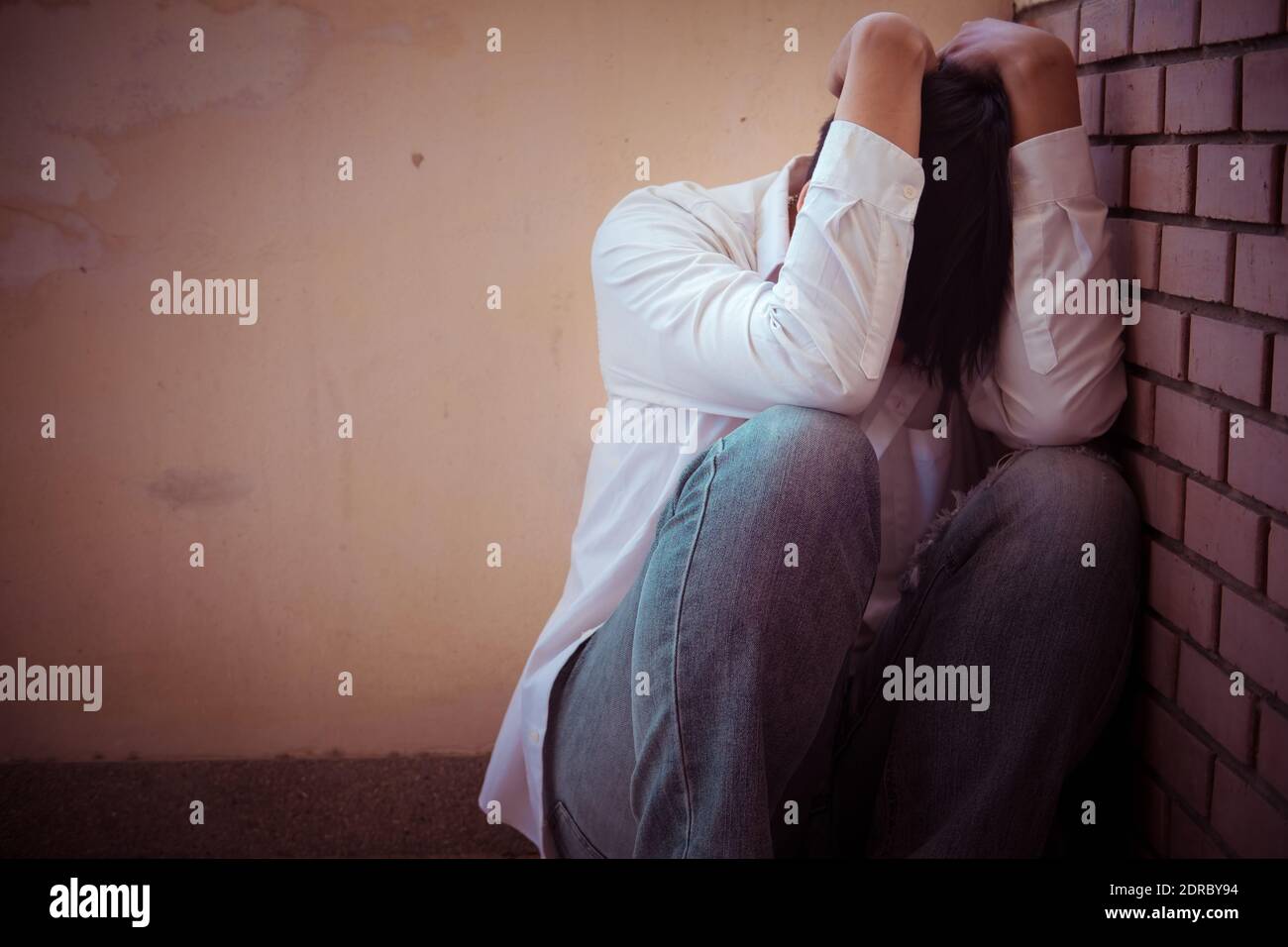 Sitting in corner head in hands hi-res stock photography and images - Alamy