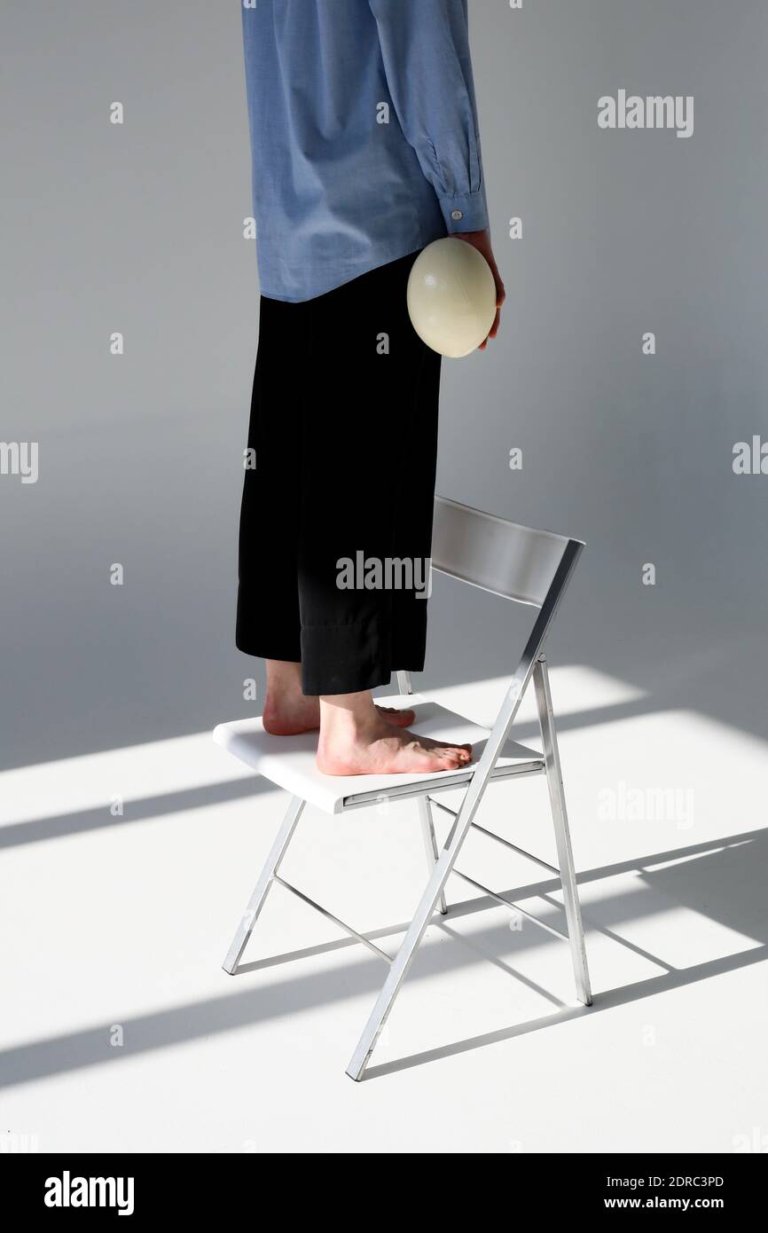 Woman standing leg on chair hi-res stock photography and images - Alamy