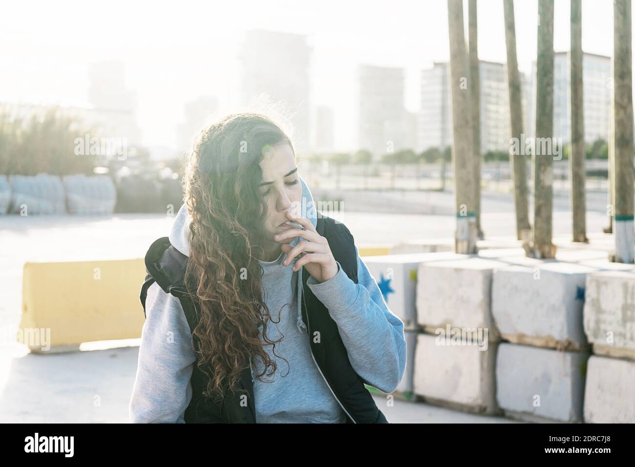 Teenage Girl Smoking Cigarette While Sitting Outdoors Stock Photo - Alamy