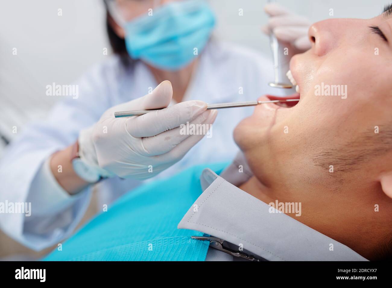 Checking teeth of male patient Stock Photo - Alamy